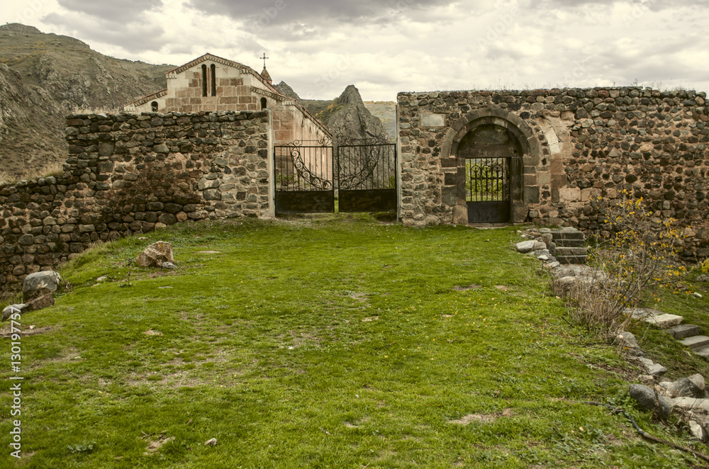Entrance door and gate to the stone wall surrounding medieval monastery ...