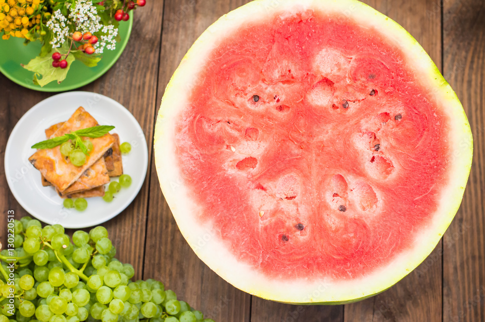 Watermelon and sultan Grapes on a wooden background. Top view. Close-up ...