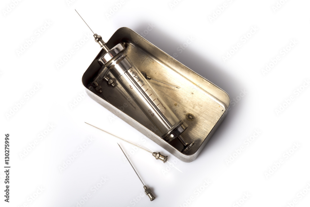 Old 10 ml glass and stainless steel medical syringe lying in stainless ...