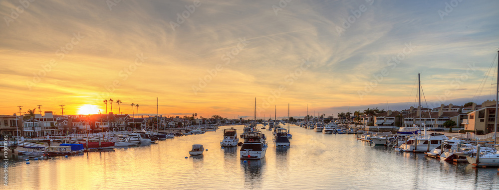 Balboa Island harbor at sunset with ships and sailboats visible from ...