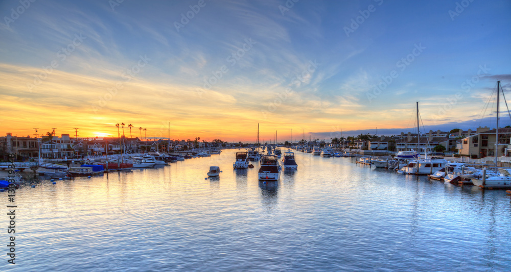Balboa Island harbor at sunset with ships and sailboats visible from ...