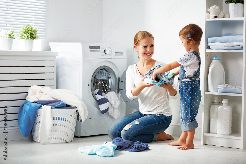 family mother and child girl in laundry room near washing machi Stock ...
