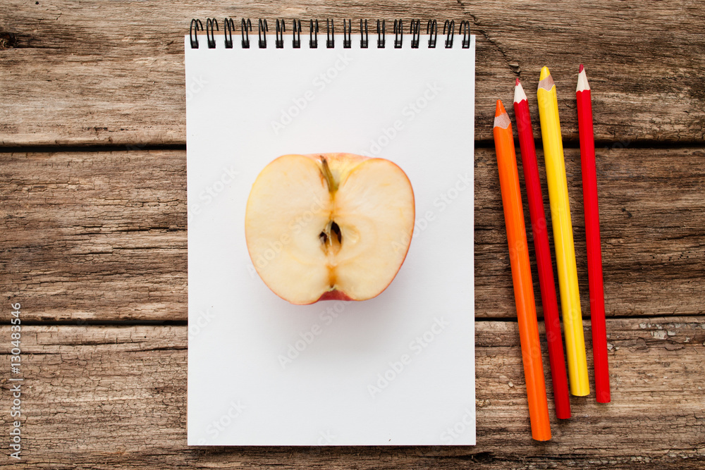 Realistic picture of apple with colorful pencils. Top view on ...