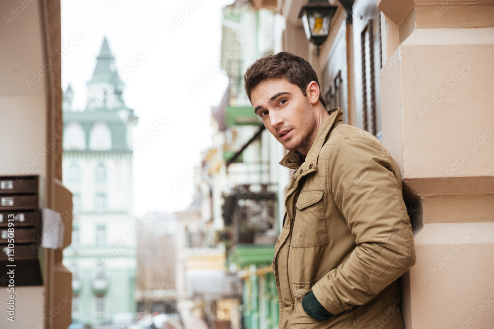 Serious young man walking on street and looking at camera. Stock Photo ...