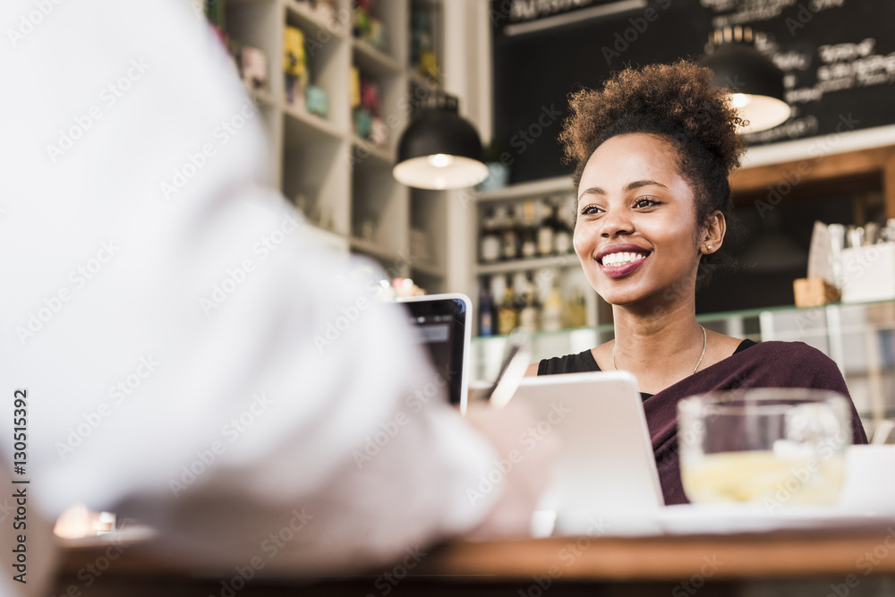 Waitress at counter in a cafe smiling at customer Stock Photo | Adobe Stock