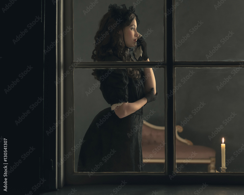 Sad retro victorian woman in black dress wiping tear standing be Stock ...