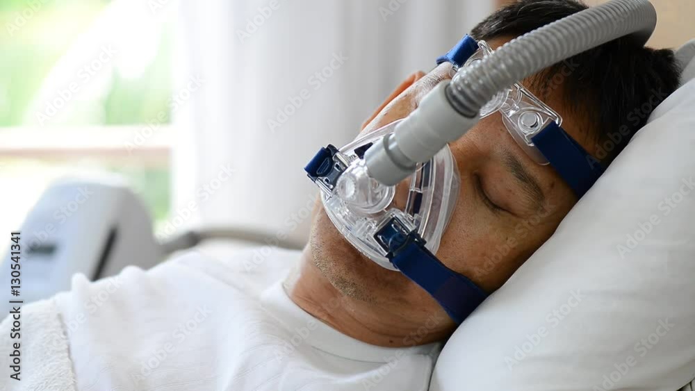 Sleep apnea therapy, Man sleeping in bed wearing CPAP mask. Healthy ...