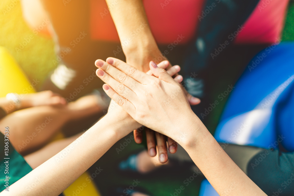 Three young business people joining hands team up, teamwork or unity ...