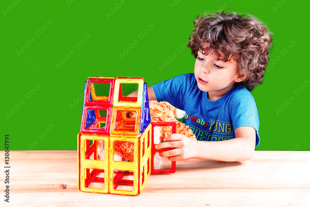 The amusing curly-headed kid plays with the cat who has got into the ...