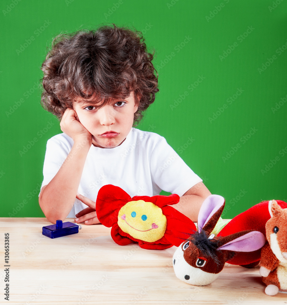 Cute little sad boy close up in white t-shirt, offended with his lips ...