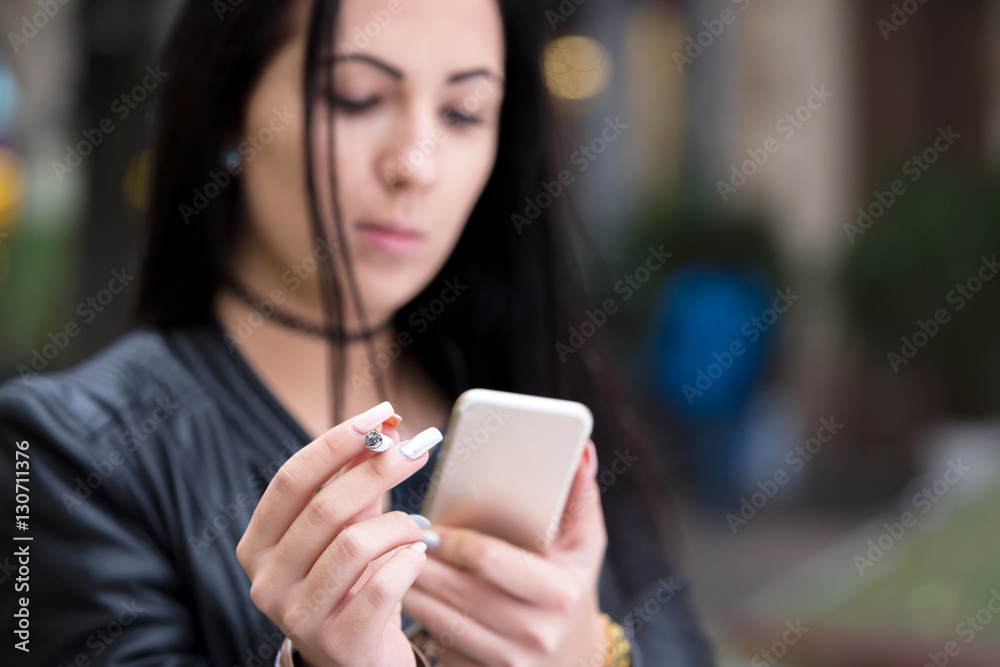 young black hair woman smoking cigarette while sending an sms in Stock ...