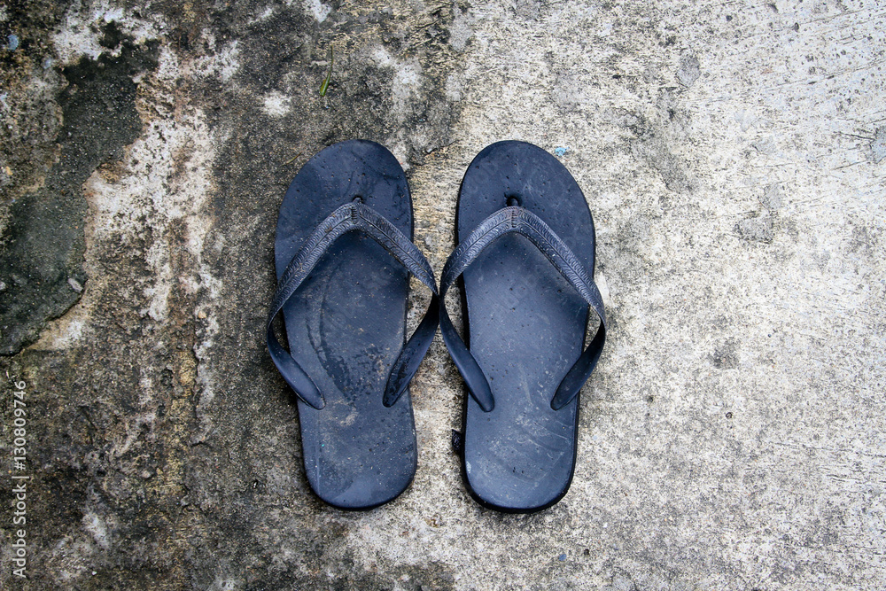 Old slippers on concrete background Stock Photo | Adobe Stock