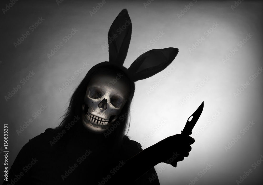 Silhouette of spooky robber or grim reapper with knife in rabbit ...