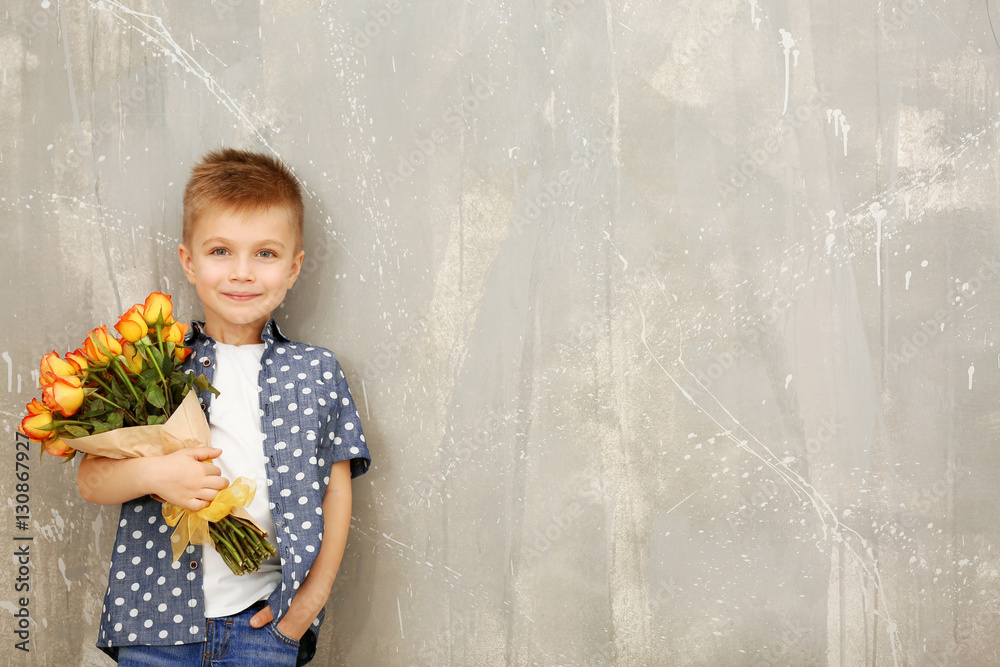 Cute boy with bouquet of beautiful flowers near grunge wall Stock-Foto ...