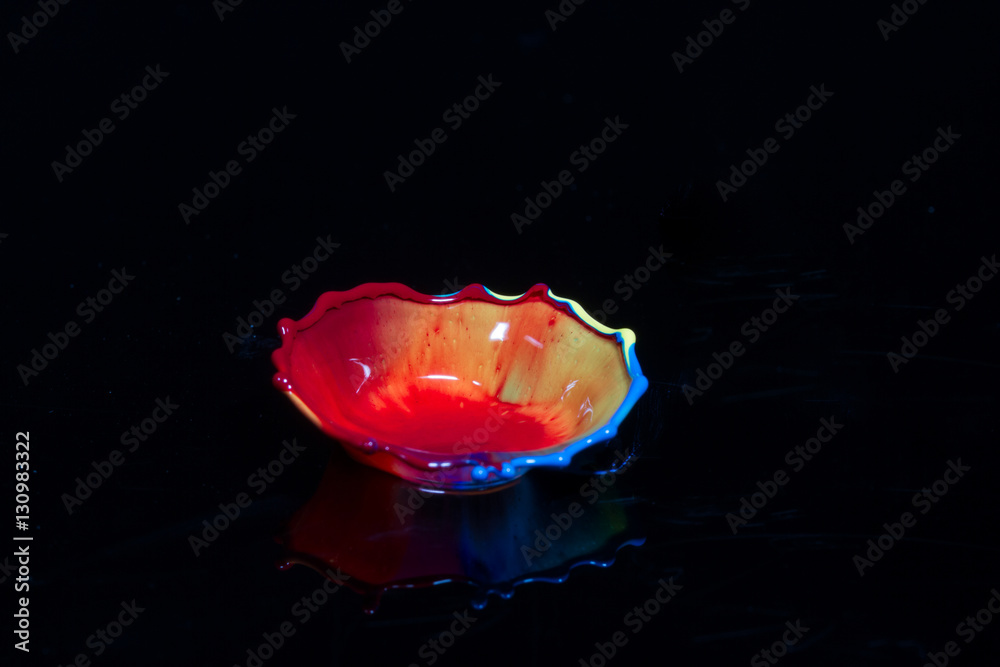 Paint drop captured as it collides with a surface producing an artistic ...