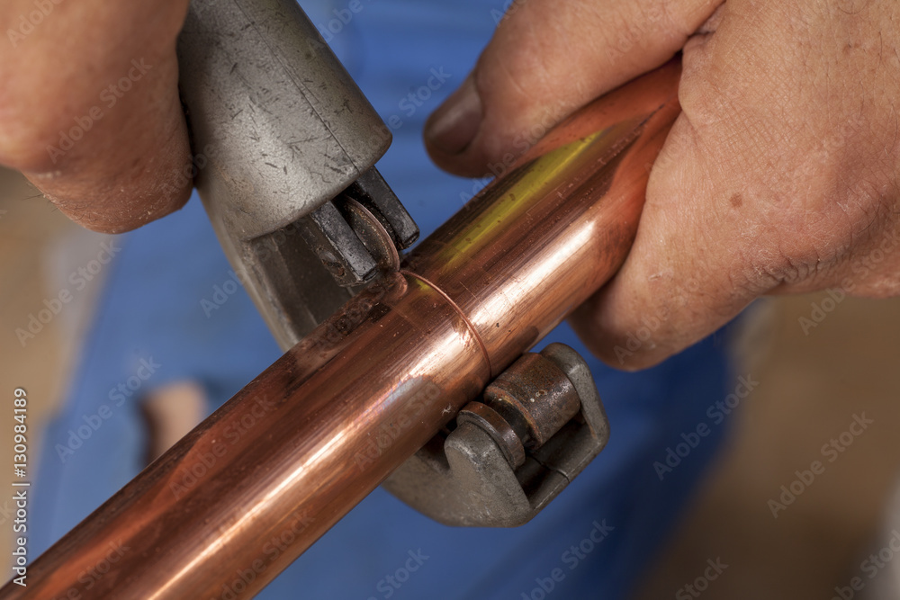 cutting copper pipes with pipe cutter Stock Photo | Adobe Stock