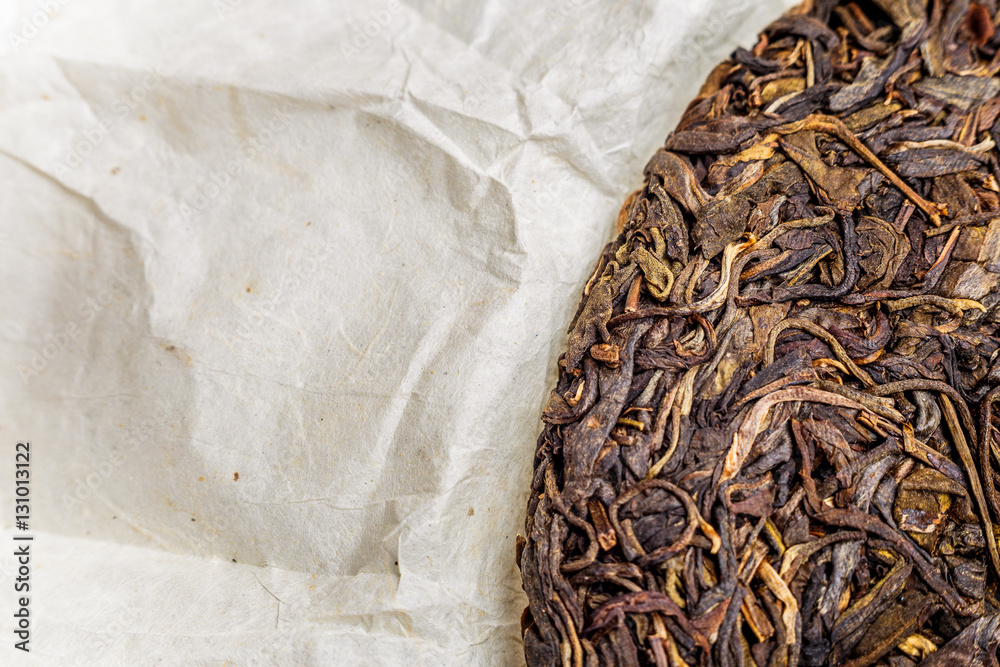 old Shen puerh chinese fermented tea on papyrus paper background with ...