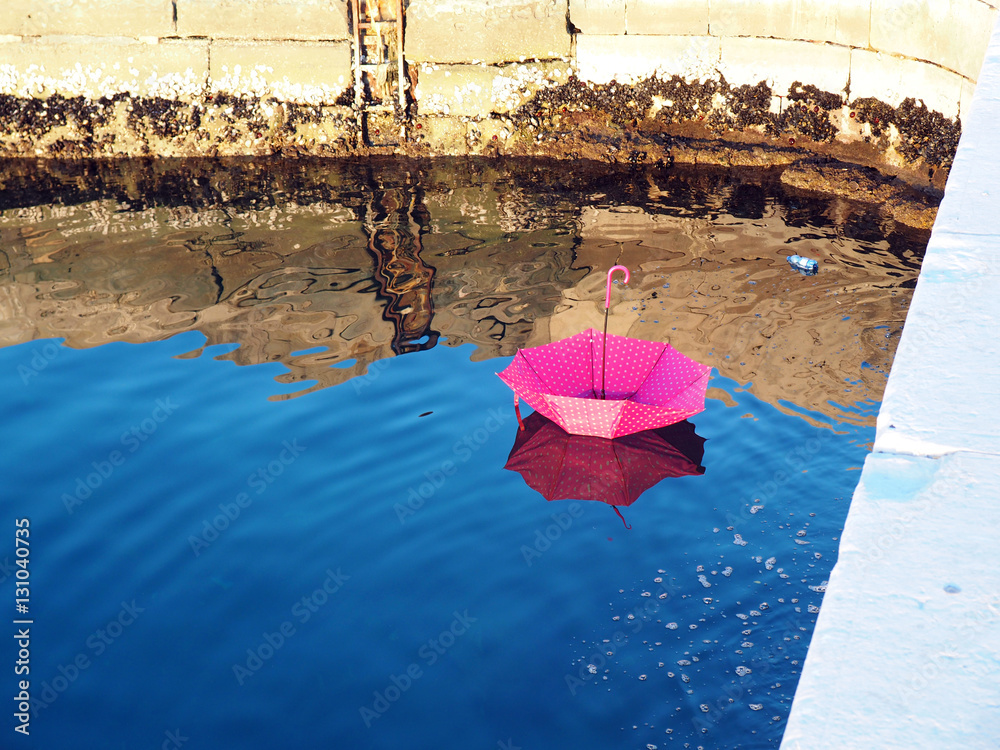 Red upturned umbrella floating on water surface 스톡 사진 | Adobe Stock