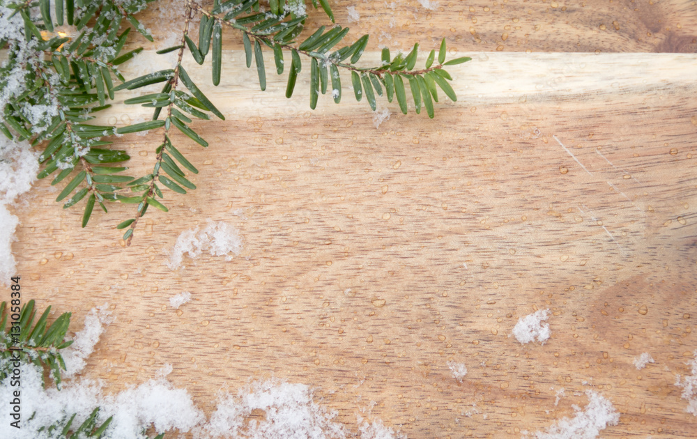 Wooden board with hemlock evergreen and snow along borders with room ...