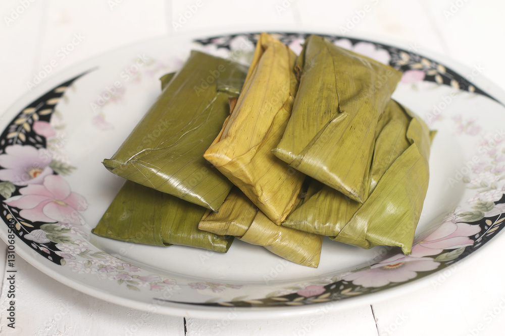 Malay dessert - Lepat Pisang -steamed banana wrapped in banana leaf Stock Photo | Adobe Stock