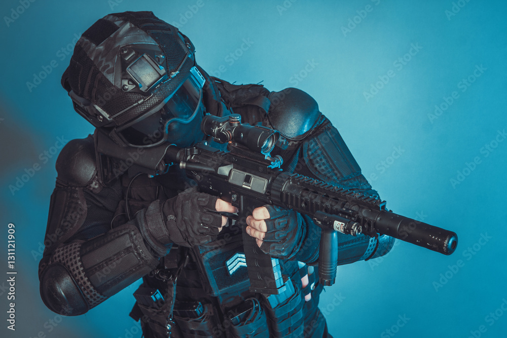 Member of the SWAT squad with an assault rifle in a black uniform on ...