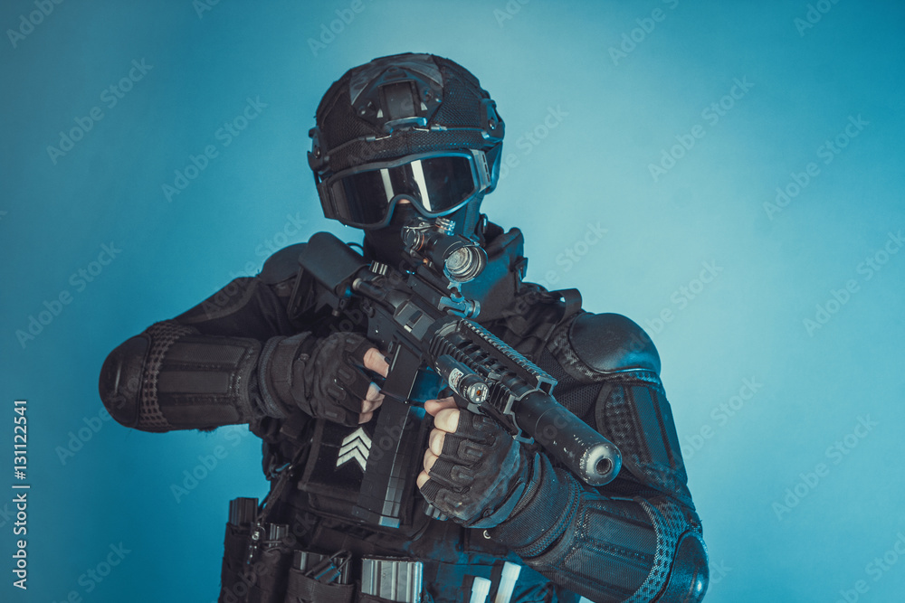 Member of the SWAT squad with an assault rifle in a black uniform on ...