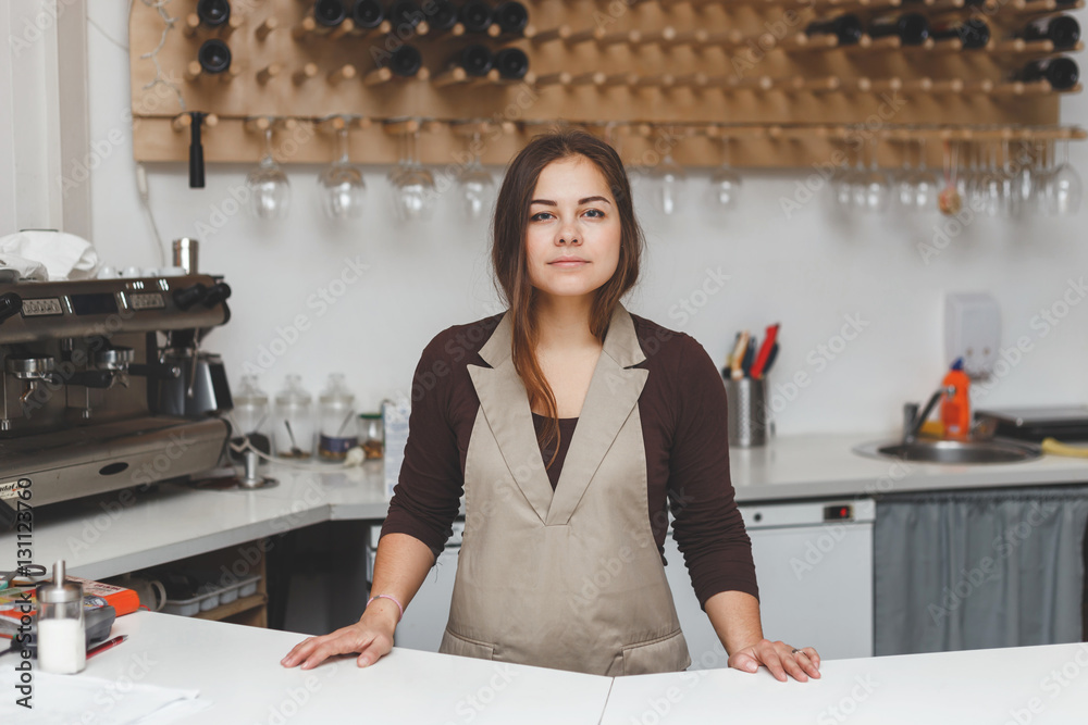 Portrait of pretty young waitress standingin cafeteria behind the counter. Stock-Foto | Adobe Stock