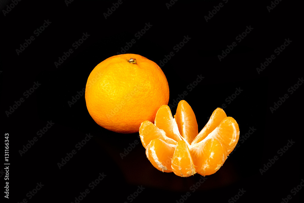 One fresh mandarin and one a peeled on a black background Stock Photo ...