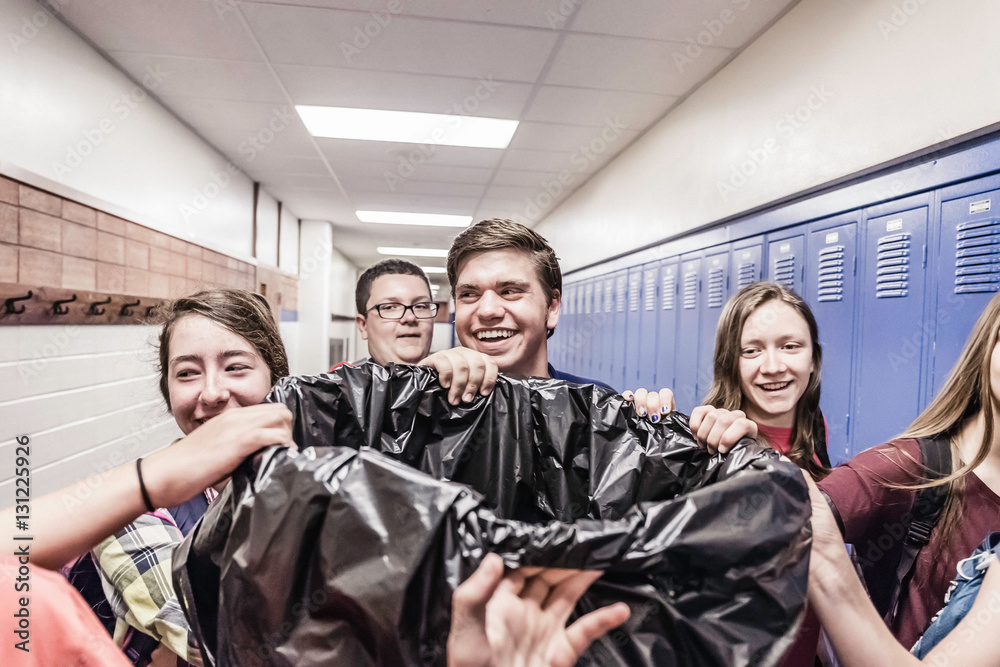 Teenage high school students carrying bin in school locker room Stock ...