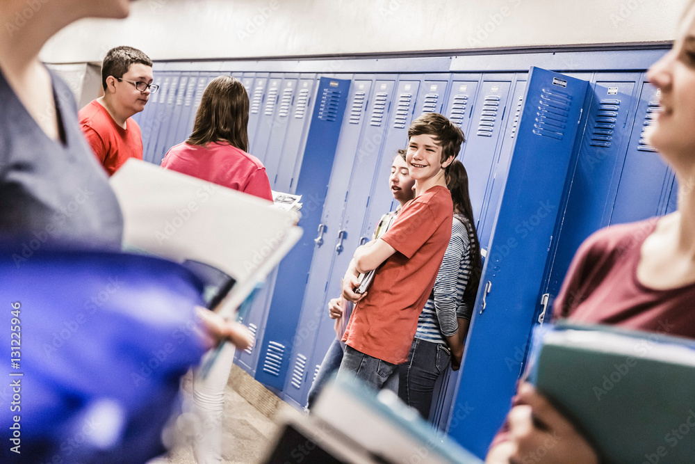 High school students holding books and notebooks in high school locker ...