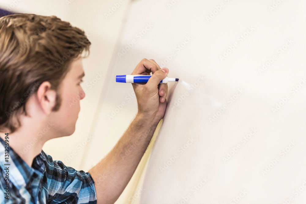 Teenage boy writing on whiteboard in high school classroom Stock Photo ...