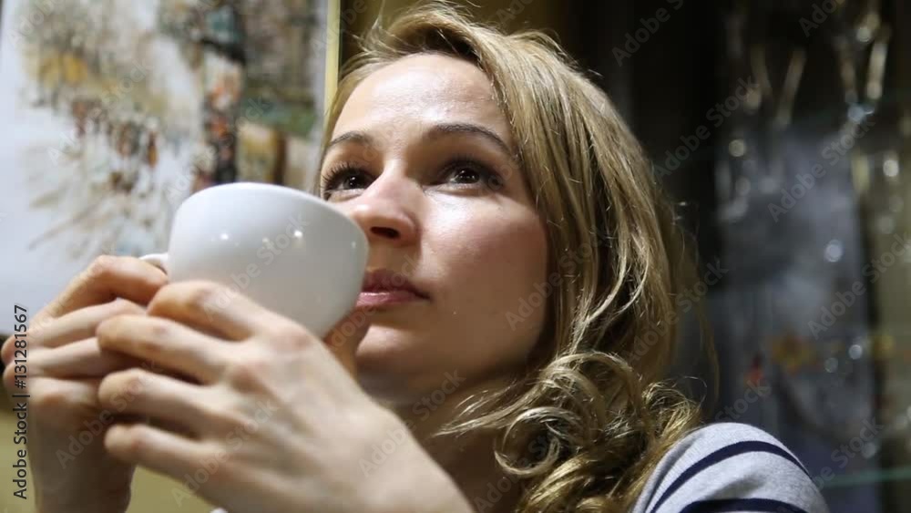 Sad, serious woman drinking coffee or tea in cafe Stock Video | Adobe Stock