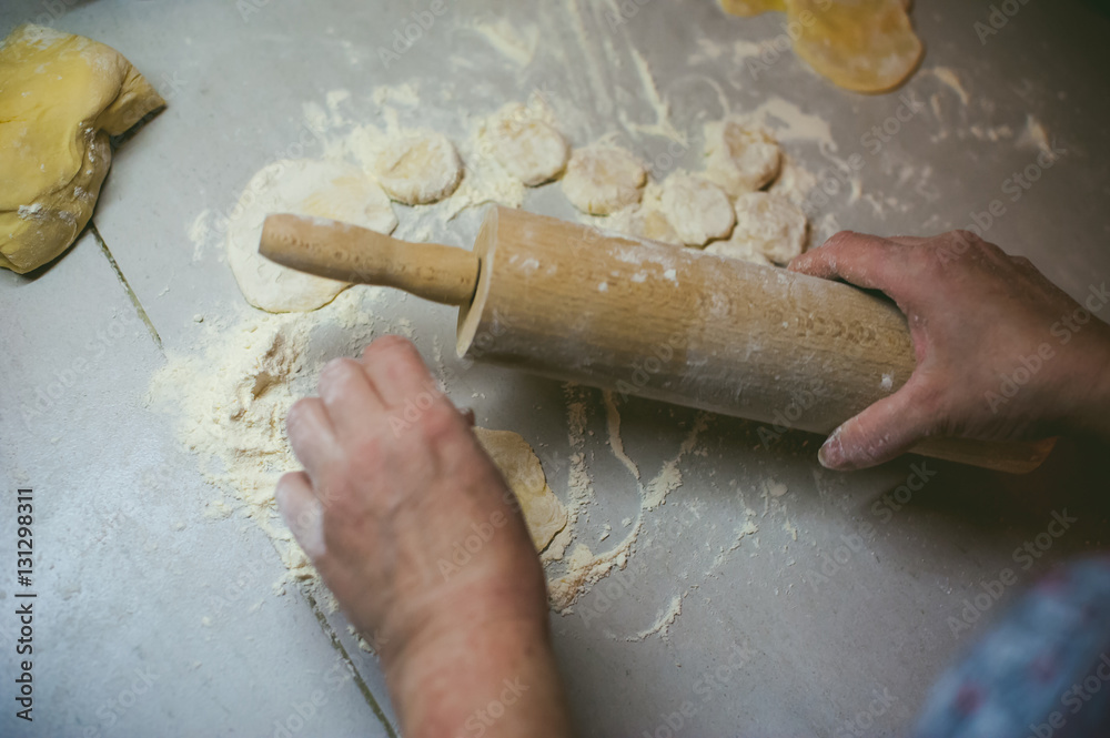 hand modeling dumplings at home in the kitchen. rolling pin in hand ...