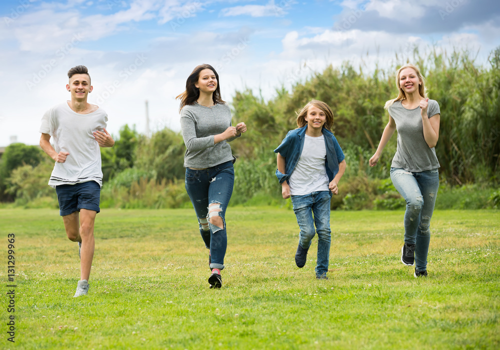 Teenagers running on green lawn in park . Stock-Foto | Adobe Stock