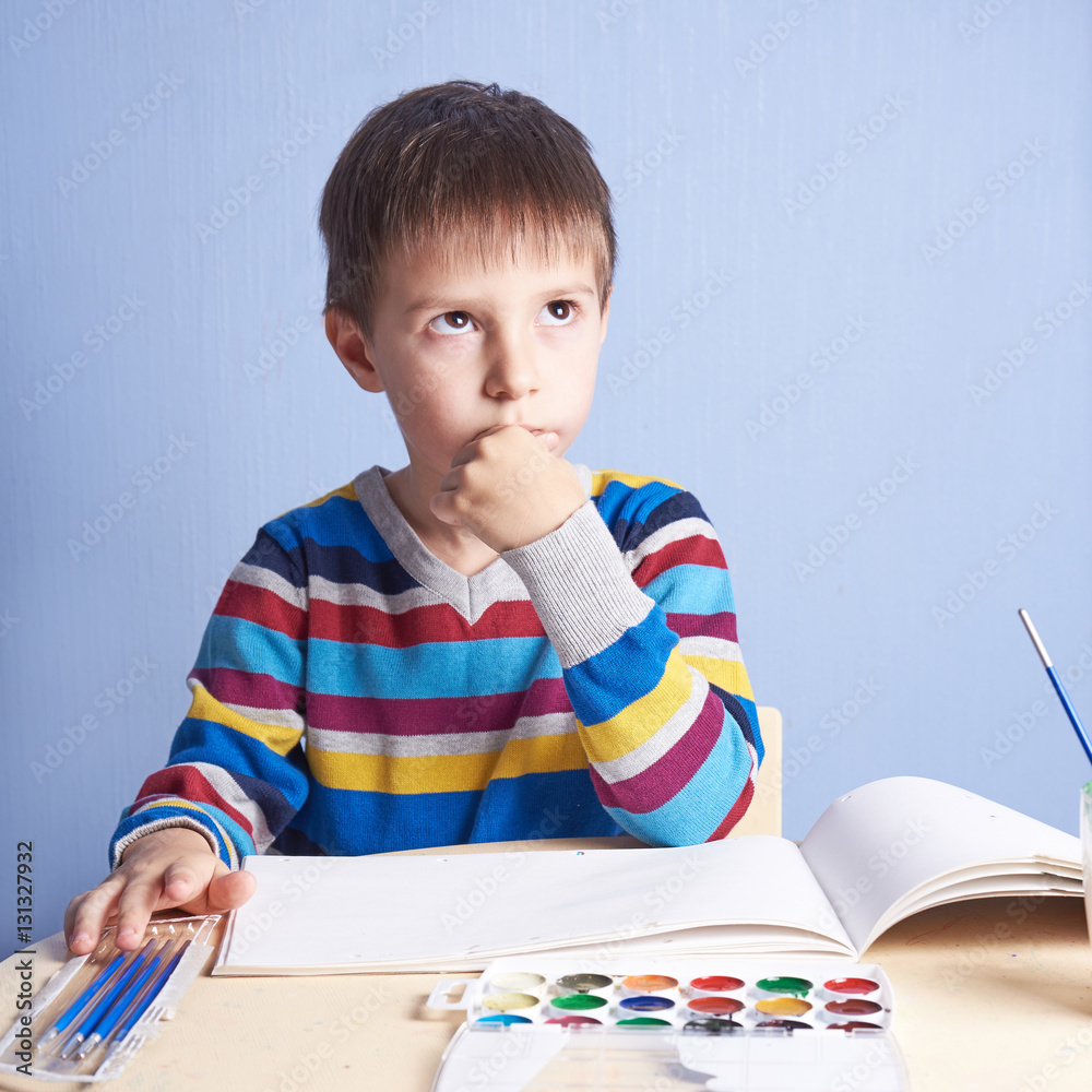 Boy thinks over his drawing content. Stock Photo | Adobe Stock