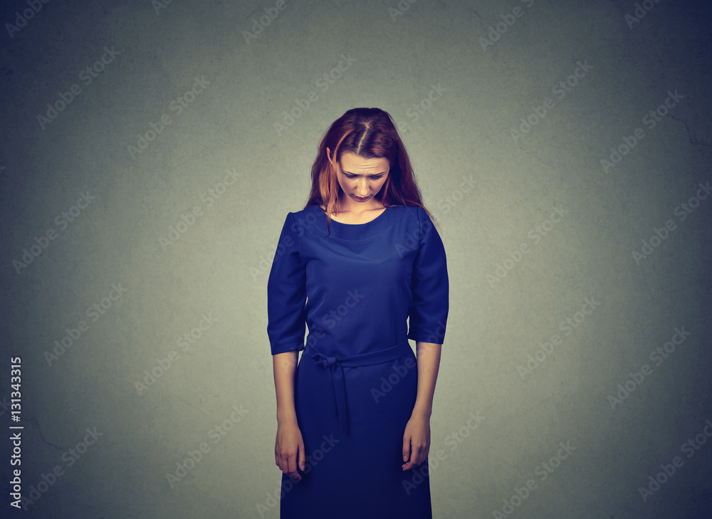 Foto de Sad shy insecure young woman standing looking down do Stock ...