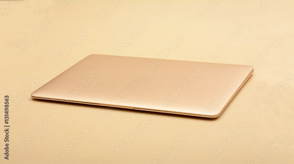 Smart Gold color laptop closed on golden background Stock Photo | Adobe ...