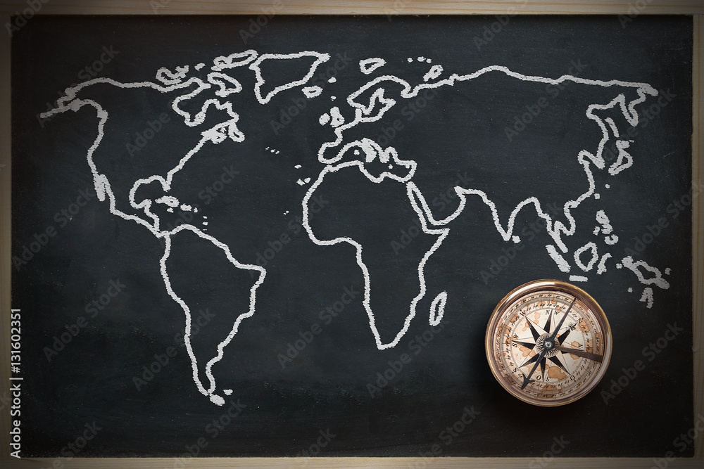 World map drawn on a blackboard and a compass. Global business ...