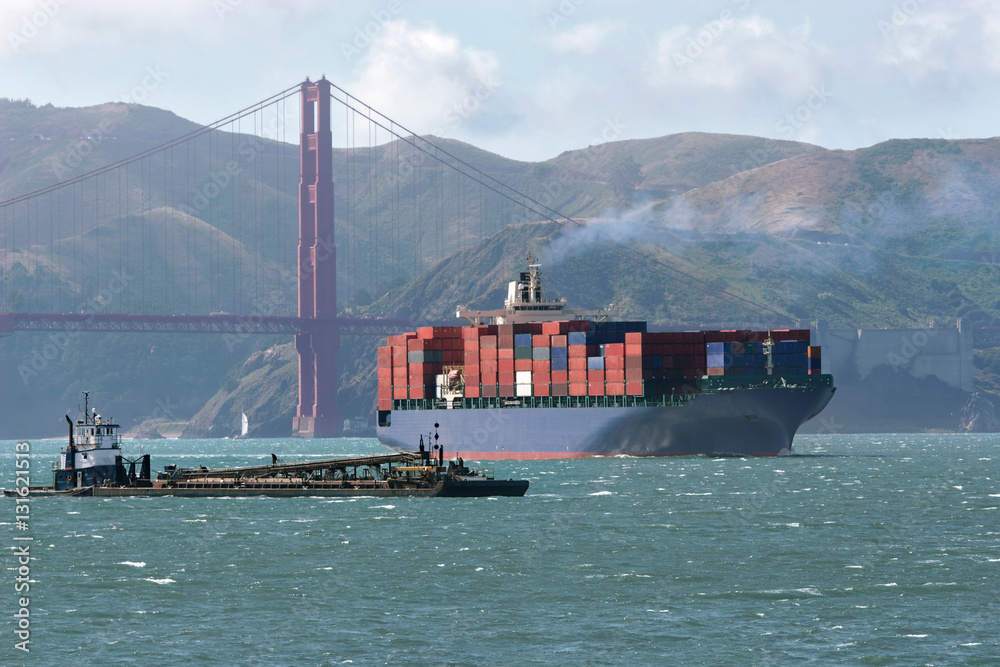 Container ship and barge at work by the Golden Gate Bridge, San ...