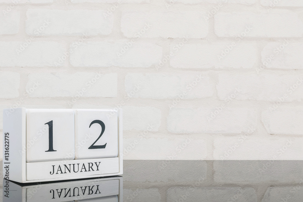 Closeup white wooden calendar with black 12 january word on black glass ...