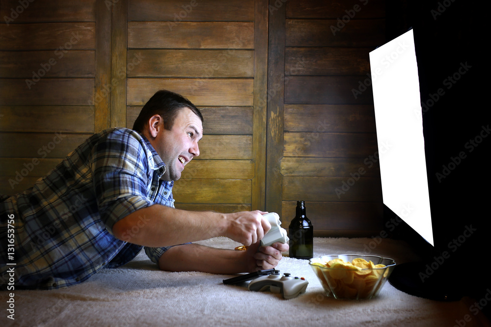 man playing on a console on the joystick before the big TV Stock Photo ...
