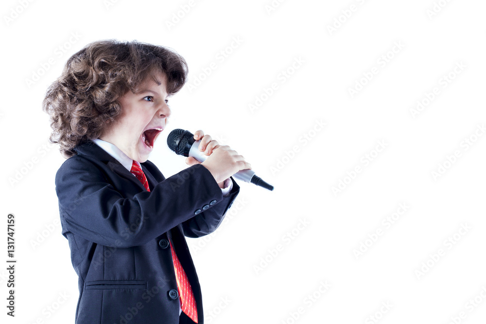 Little curly singer with a microphone in hands sings a song. In profile ...