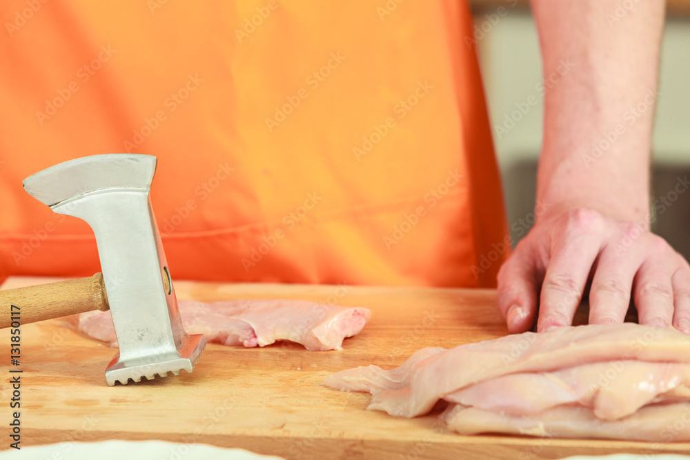Man beating chicken meat on wooden board Stock Photo | Adobe Stock