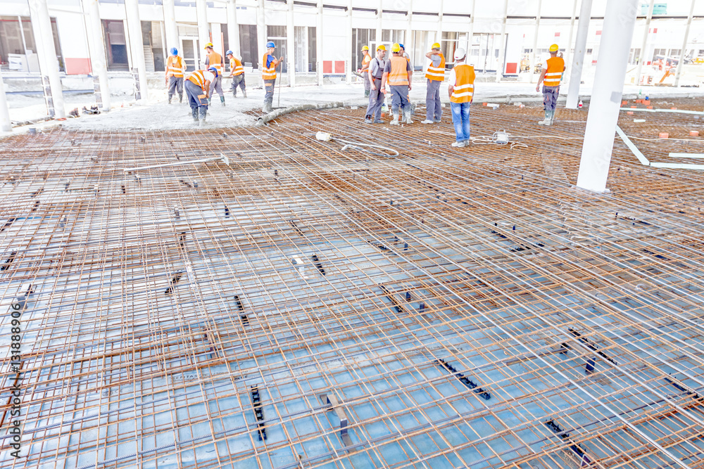 Workers are spreading concrete over big reinforced floor on the Stock ...