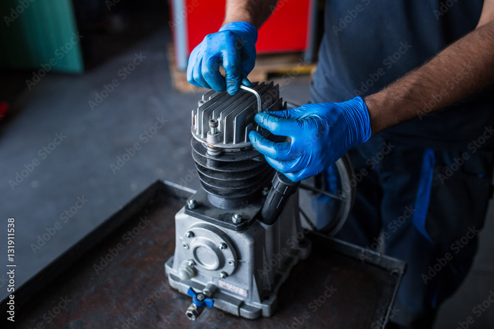 Mechanic fixing a compressor engine Stock Photo | Adobe Stock