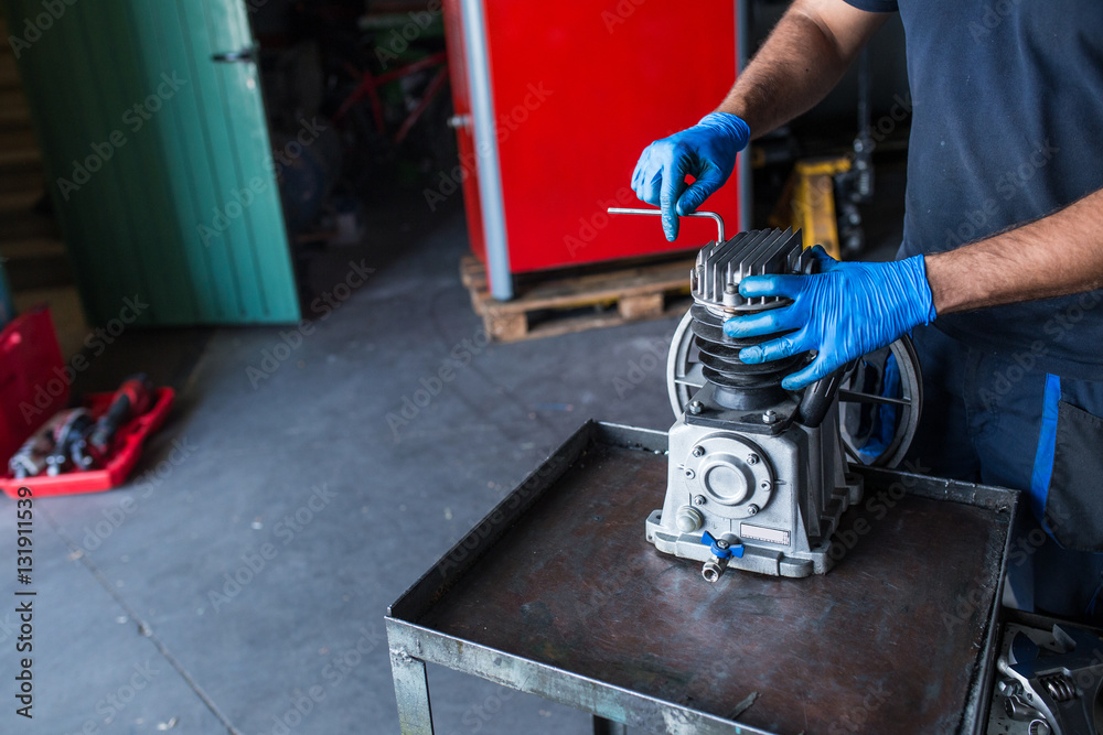 Mechanic fixing a compressor engine Stock Photo | Adobe Stock