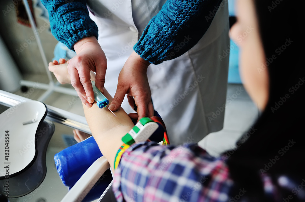 Doctor making blood analysis young girl patient. Blood sampling from a ...