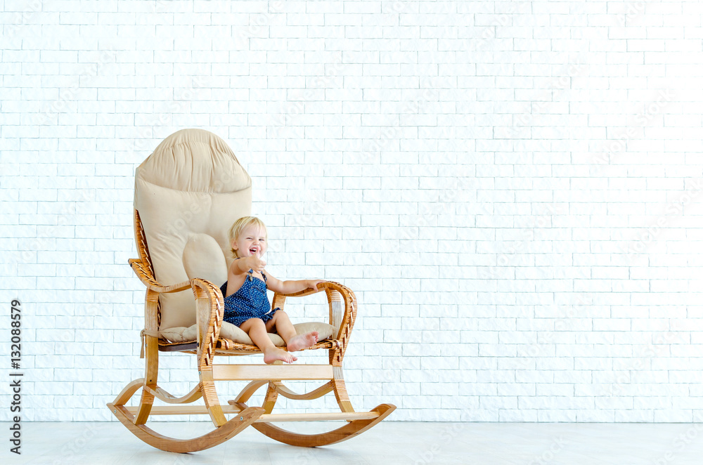 Little girl rides a rocking chair on the background of a white b Stock ...