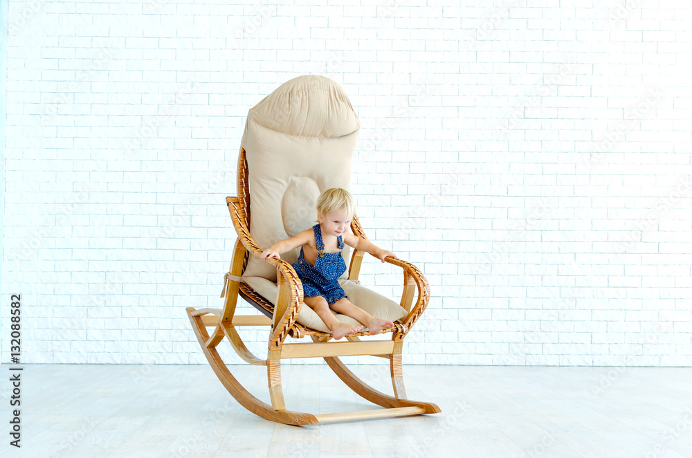 Little girl rides a rocking chair on the background of a white b Stock ...