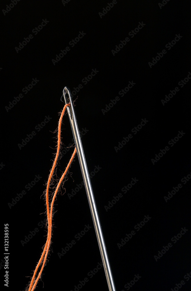 Needle and thread through on black background Stock Photo | Adobe Stock